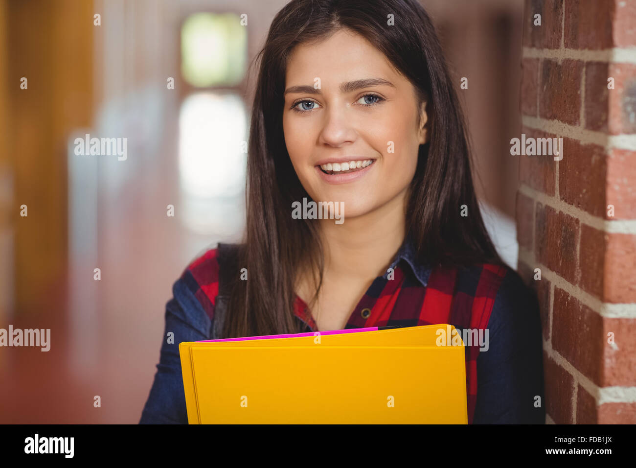 Smiling student with binder posing Stock Photo - Alamy