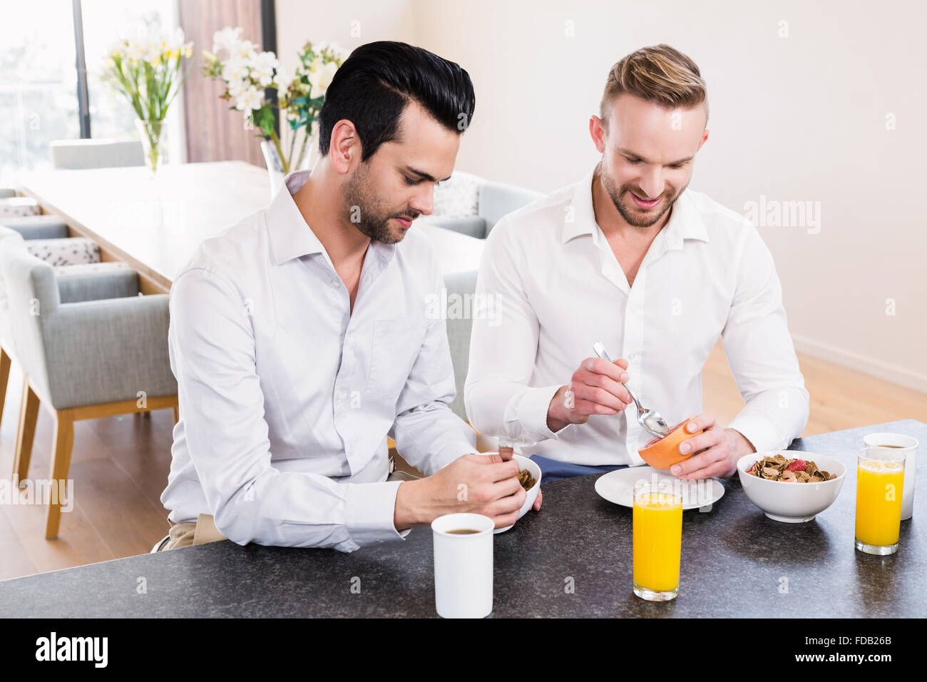 Smiling gay couple having breakfast Stock Photo - Alamy