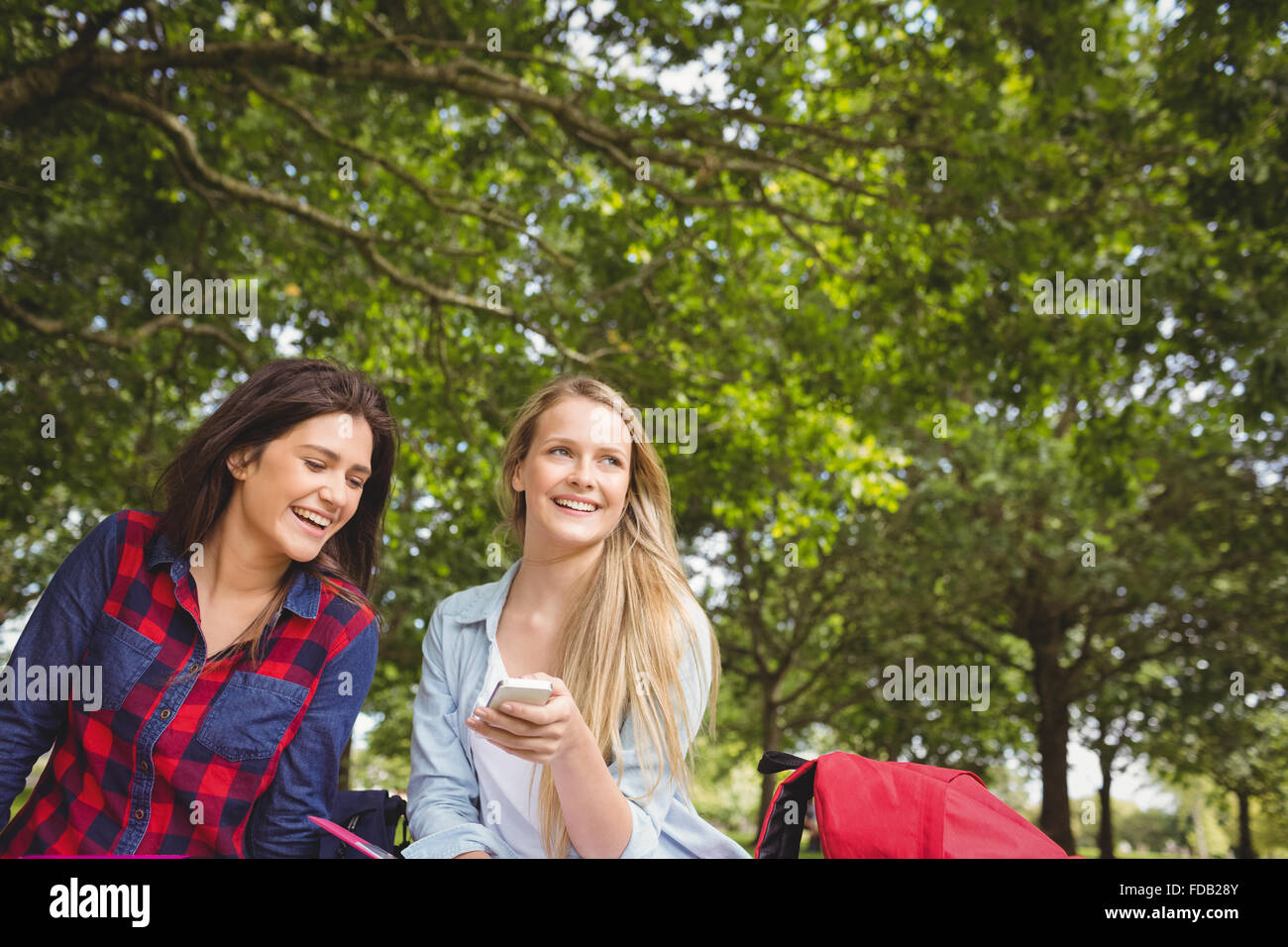 Smiling students using smartphone Stock Photo - Alamy