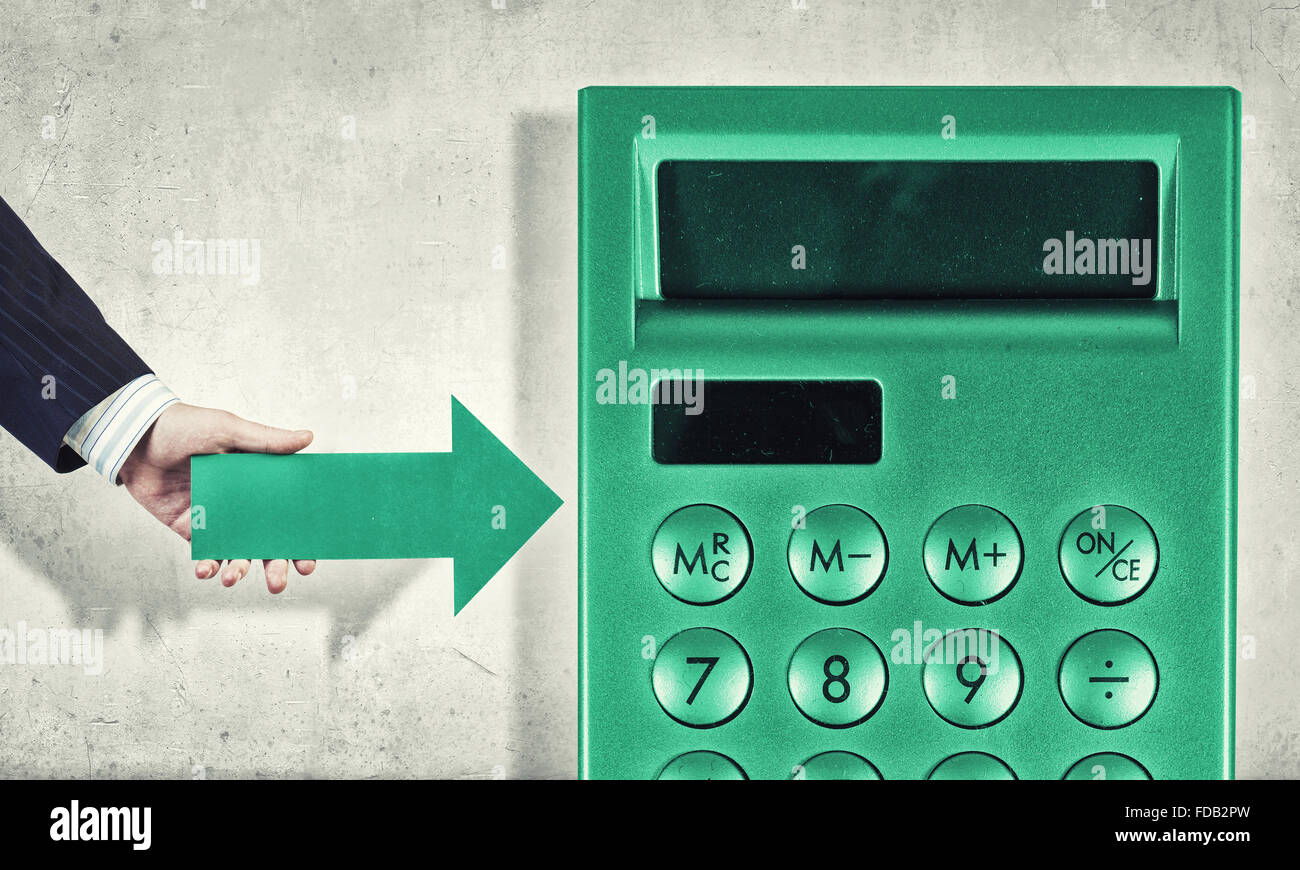Businessman hand with arrow pointing at calculator Stock Photo - Alamy