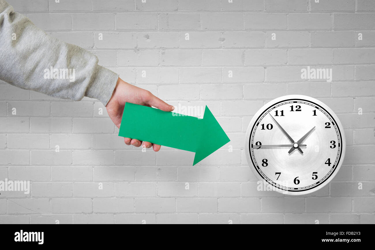 Hand of business person pointing with arrow at clock Stock Photo - Alamy