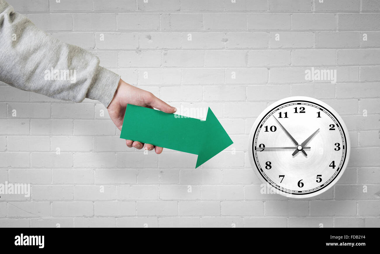 Hand of business person pointing with arrow at clock Stock Photo - Alamy