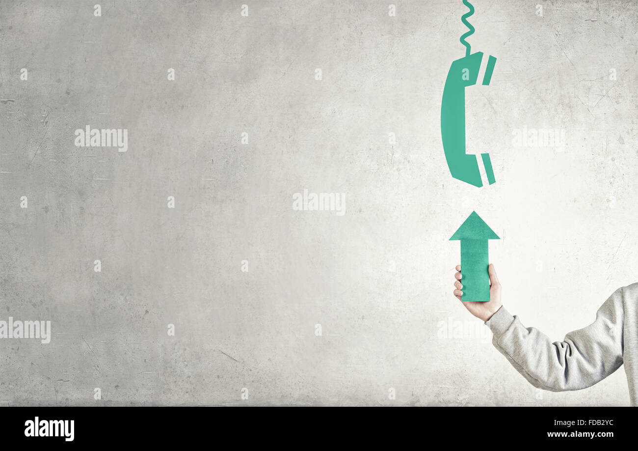 Hand of businessman holding green arrow and pointing at calls sign ...
