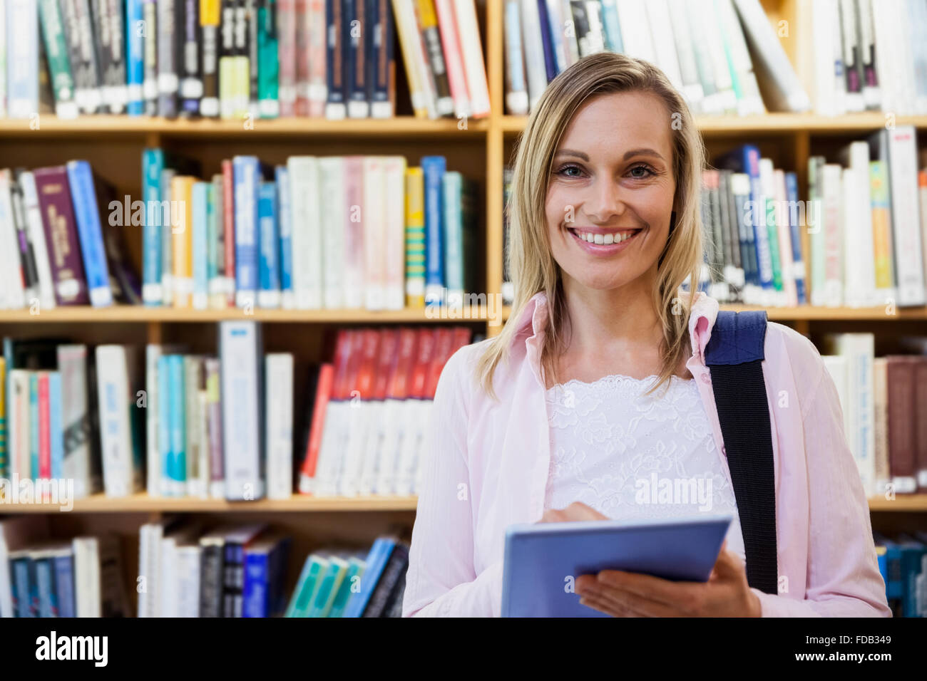 Female student using tablet in library Stock Photo - Alamy