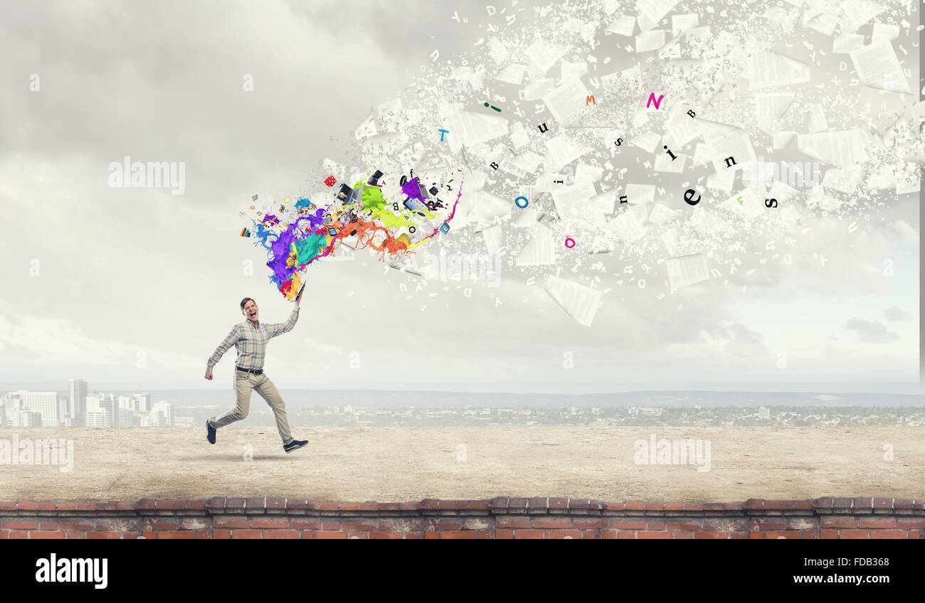 Full length of student running with book in hand Stock Photo - Alamy