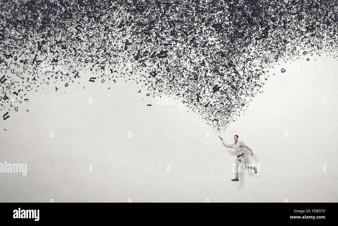 Full length of student running with book in hand Stock Photo - Alamy