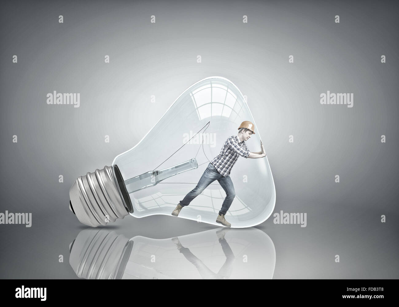 Builder man inside light bulb trying to get out Stock Photo - Alamy
