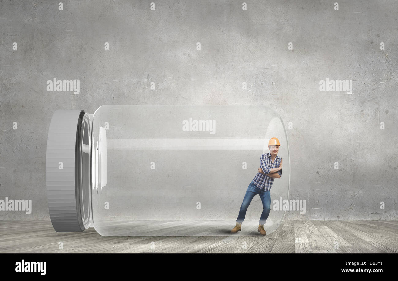 Builder man trapped in glass jar trying to escape Stock Photo - Alamy