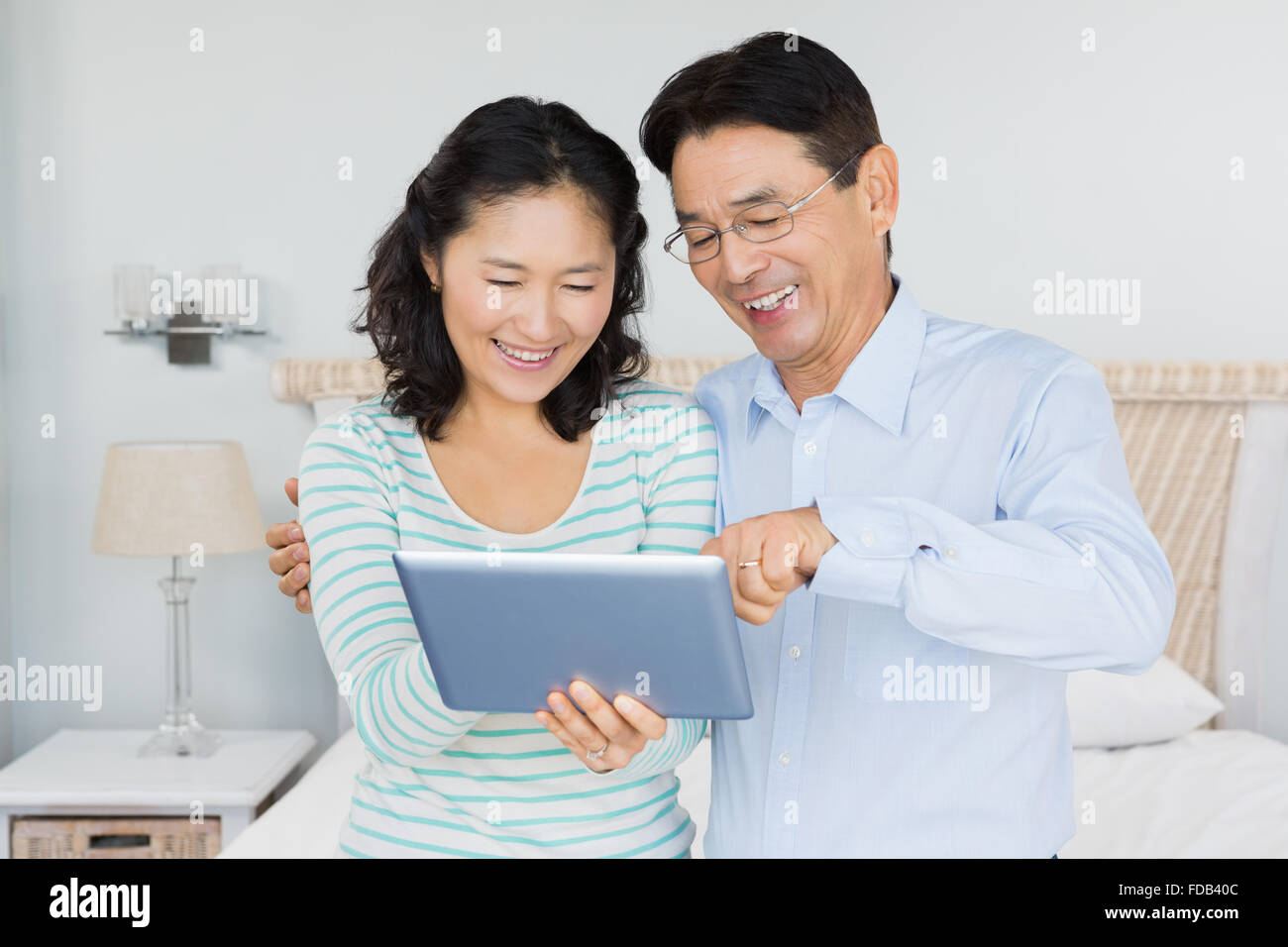 Happy couple using tablet Stock Photo - Alamy