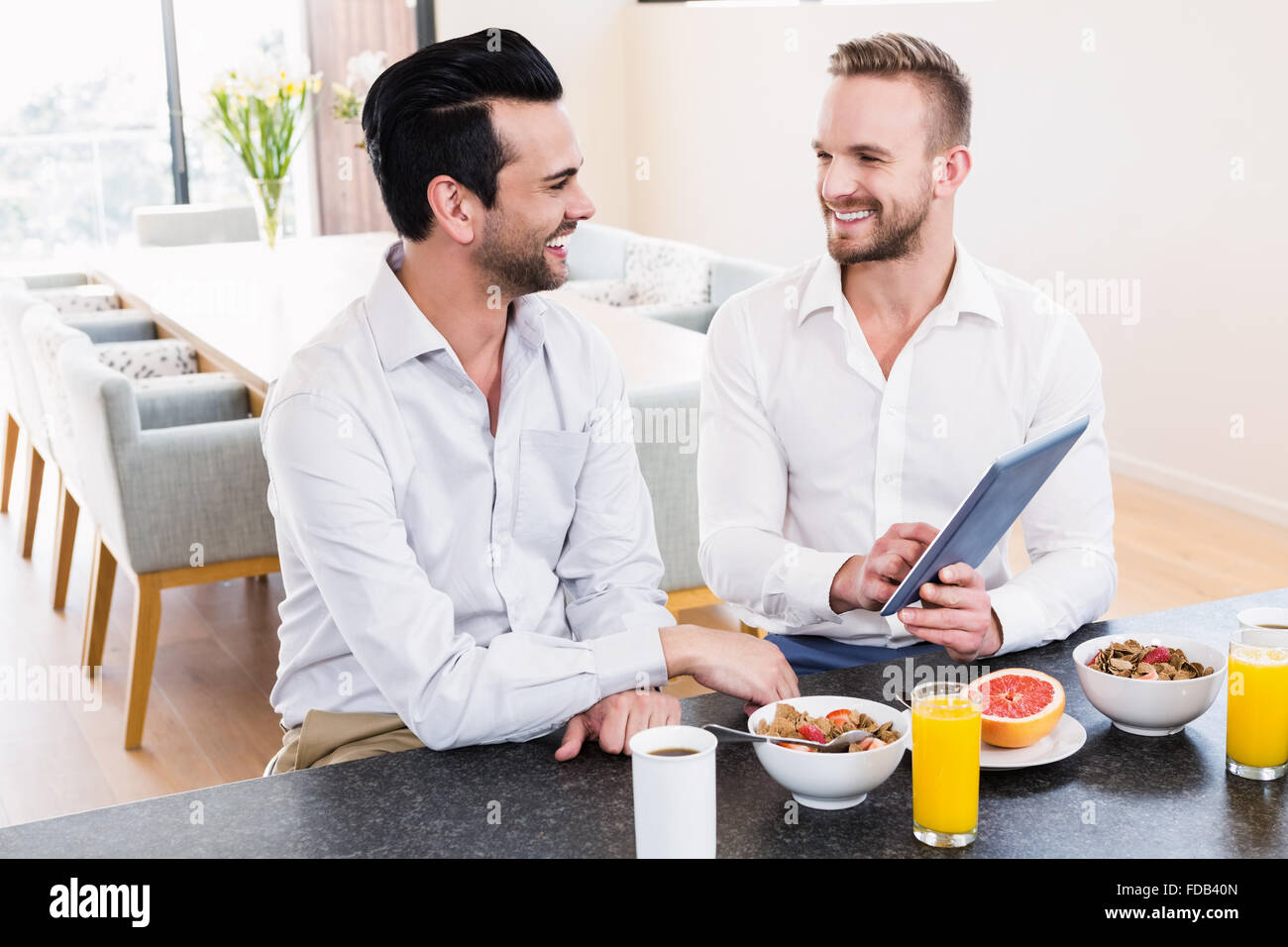 Smiling gay couple having breakfast Stock Photo - Alamy