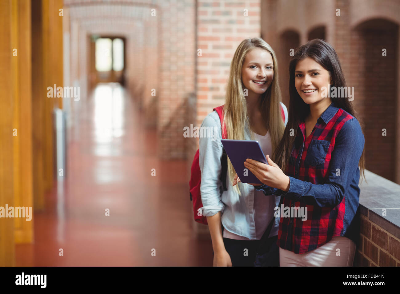 Smiling students using tablet together Stock Photo - Alamy