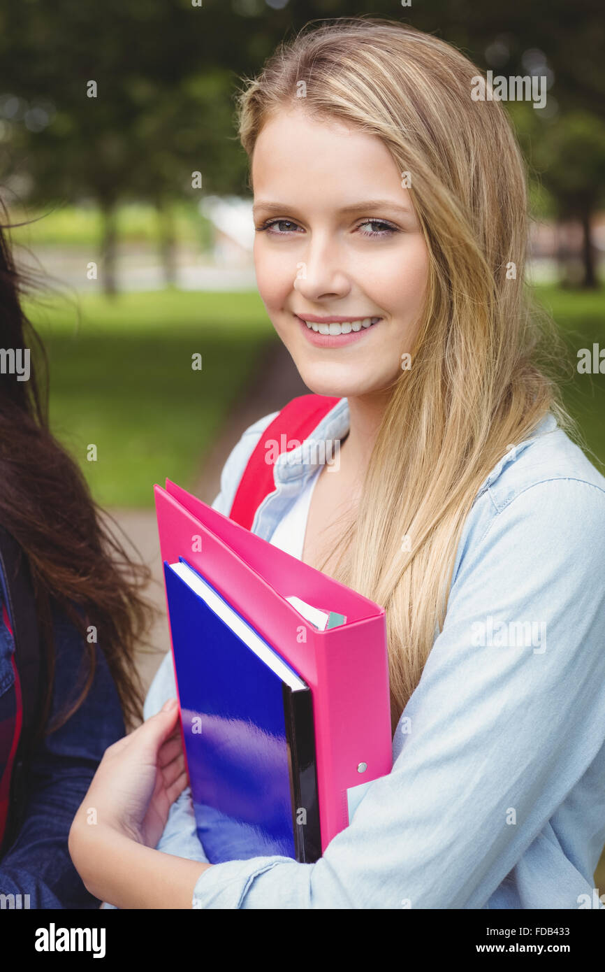 Smiling student holding binder Stock Photo - Alamy
