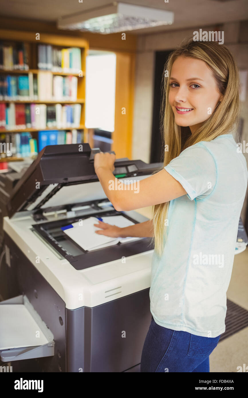 Smiling blonde student making a copy Stock Photo - Alamy