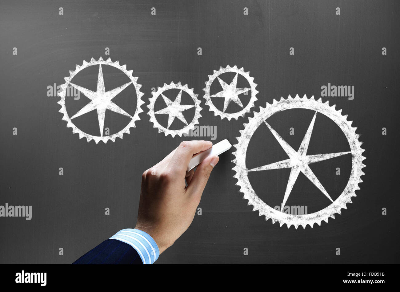 Businessman hand drawing with chalk gears mechanism as teamwork concept ...
