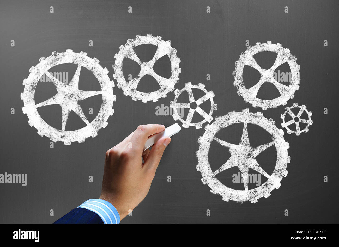 Businessman hand drawing with chalk gears mechanism as teamwork concept ...