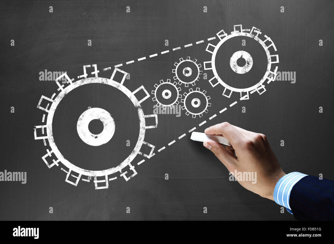 Businessman hand drawing with chalk gears mechanism as teamwork concept ...