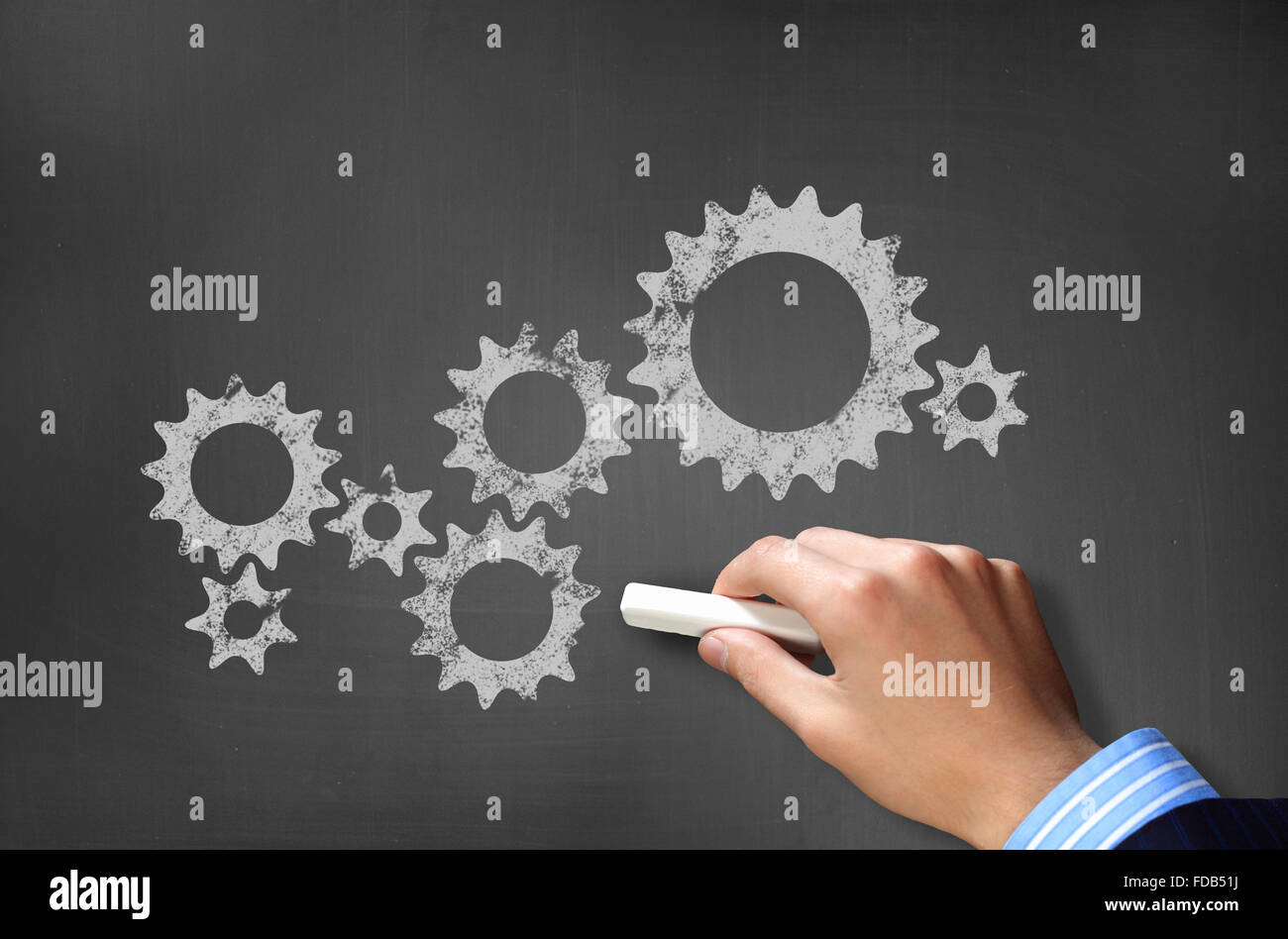 Businessman hand drawing with chalk gears mechanism as teamwork concept ...