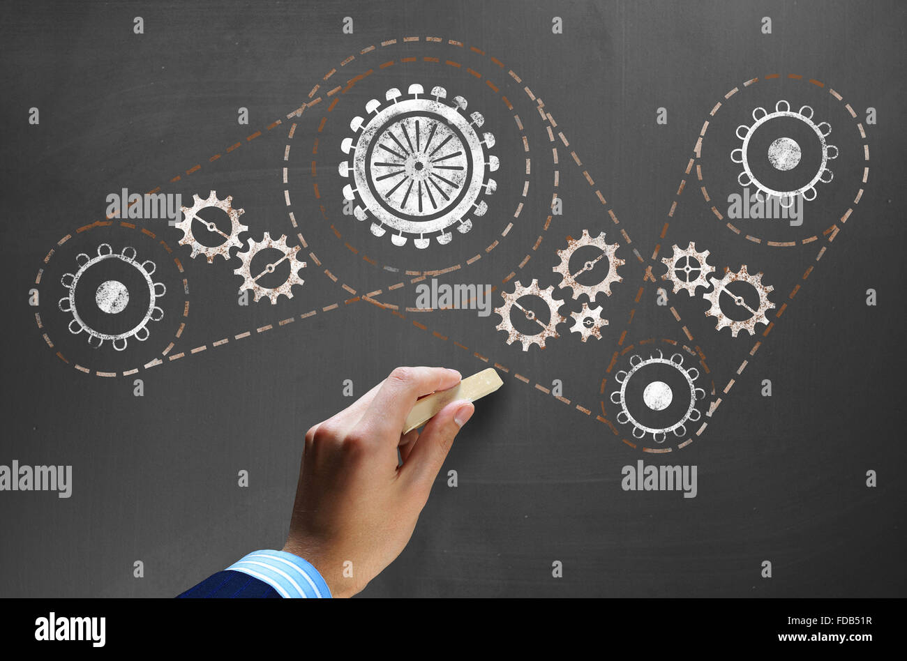 Businessman hand drawing with chalk gears mechanism as teamwork concept ...