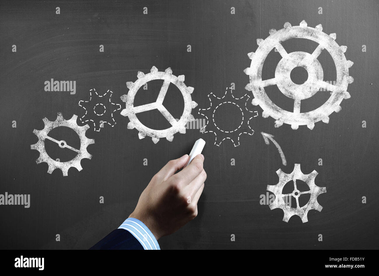 Businessman hand drawing with chalk gears mechanism as teamwork concept ...