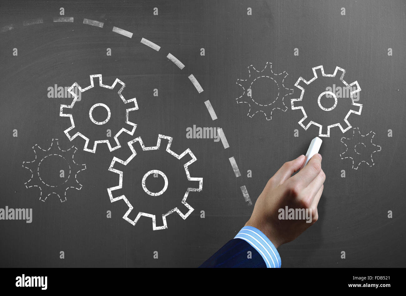 Businessman hand drawing with chalk gears mechanism as teamwork concept ...
