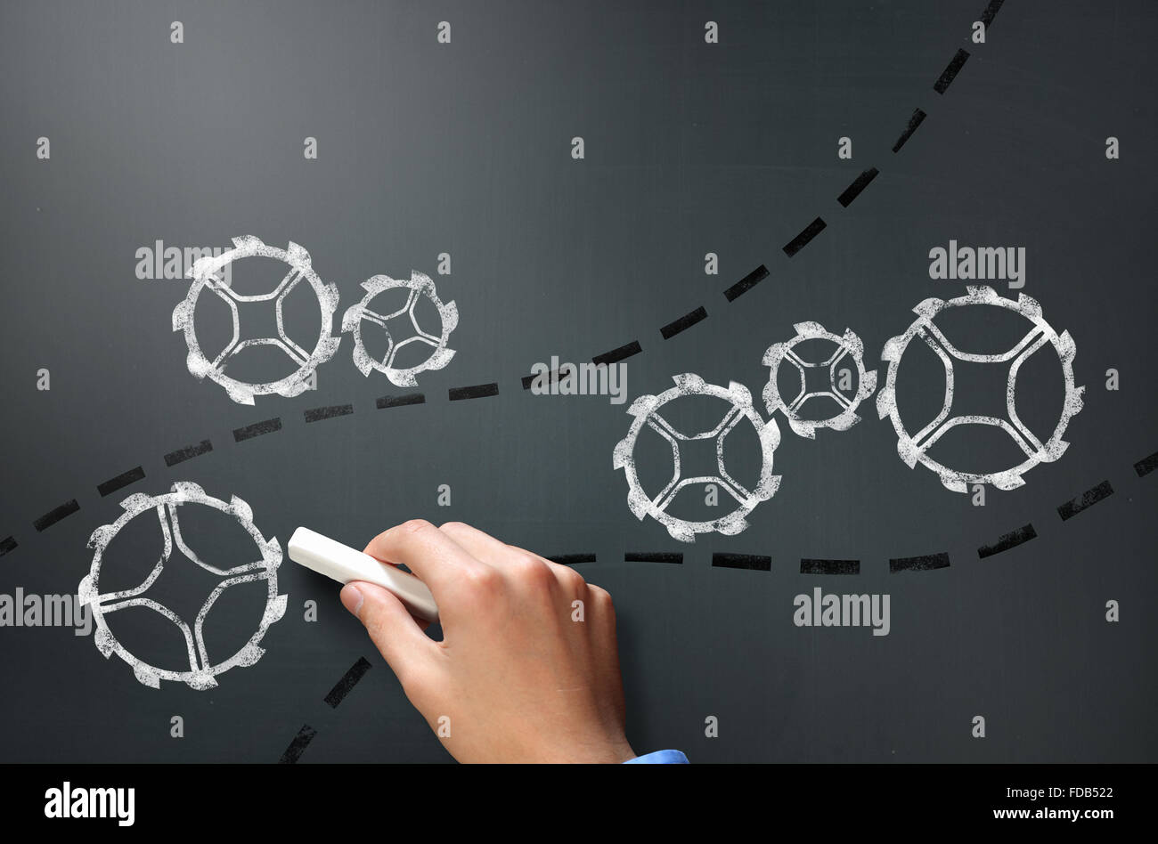Businessman hand drawing with chalk gears mechanism as teamwork concept ...