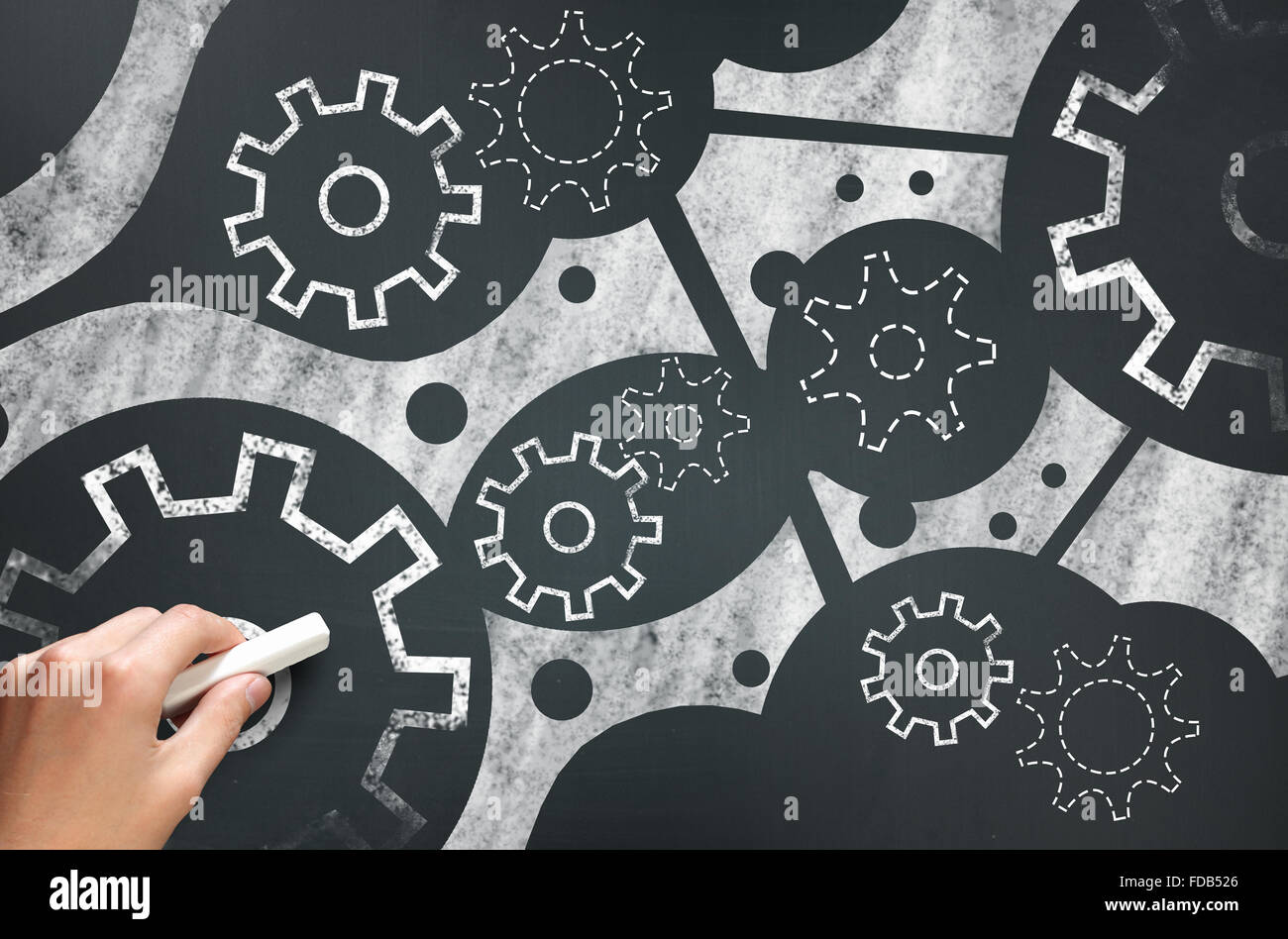 Businessman hand drawing with chalk gears mechanism as teamwork concept ...