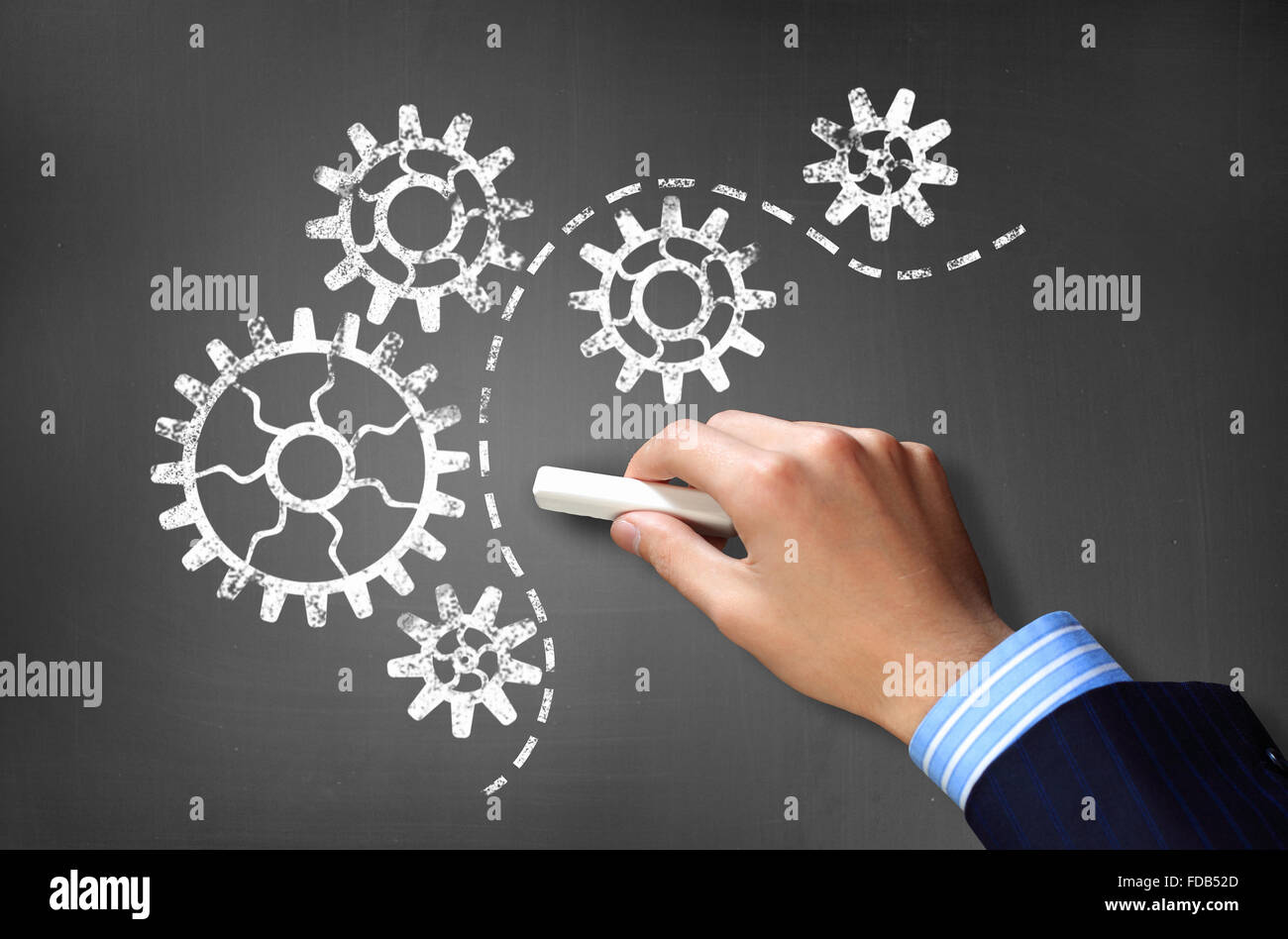 Businessman hand drawing with chalk gears mechanism as teamwork concept ...