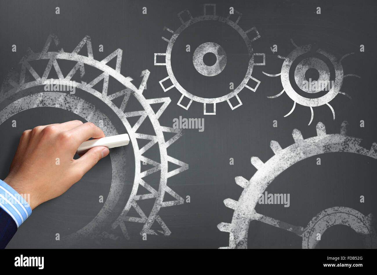 Businessman hand drawing with chalk gears mechanism as teamwork concept ...