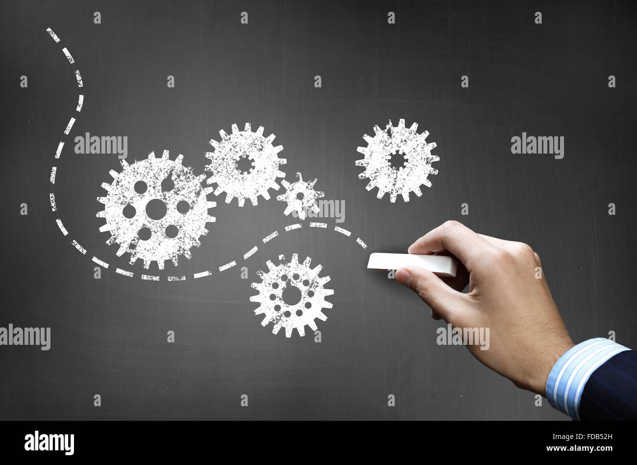 Businessman hand drawing with chalk gears mechanism as teamwork concept ...