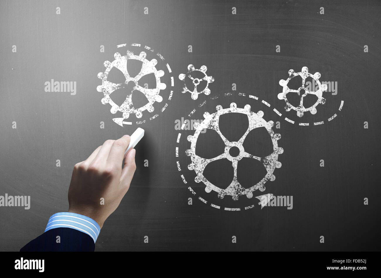 Businessman hand drawing with chalk gears mechanism as teamwork concept ...