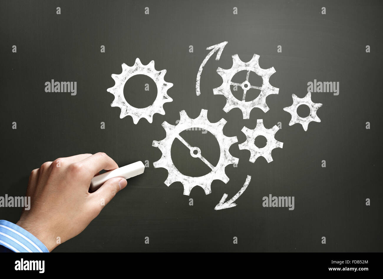 Businessman hand drawing with chalk gears mechanism as teamwork concept ...