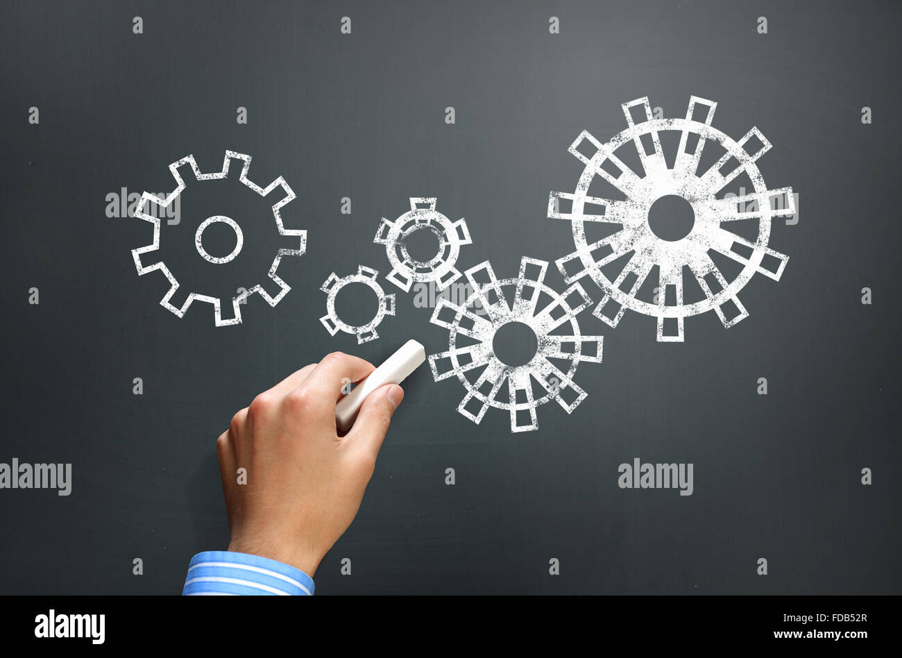 Businessman hand drawing with chalk gears mechanism as teamwork concept ...