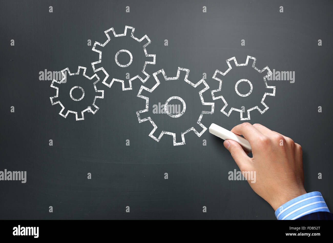 Businessman hand drawing with chalk gears mechanism as teamwork concept ...