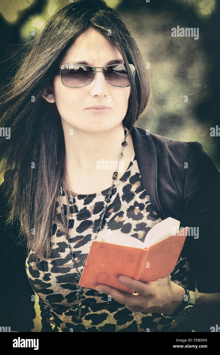 Serious woman reading a book with a nature background isolated Stock ...