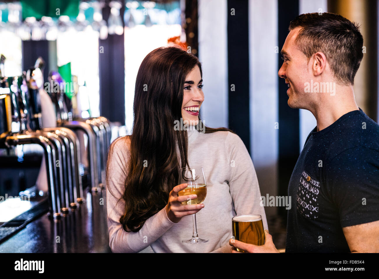 Cute couple talking in a bar Stock Photo - Alamy