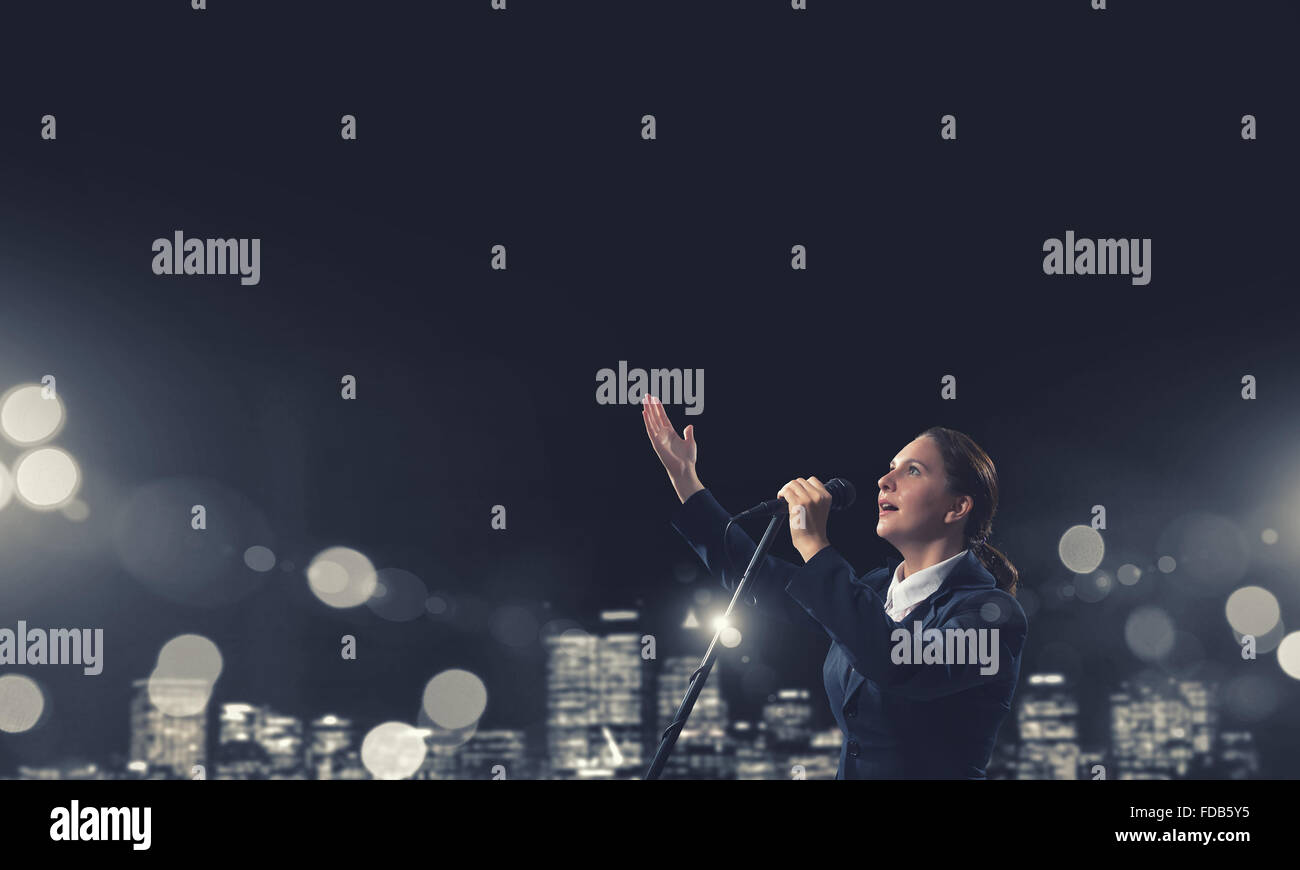 Woman reporter with microphone gesturing with hand Stock Photo - Alamy