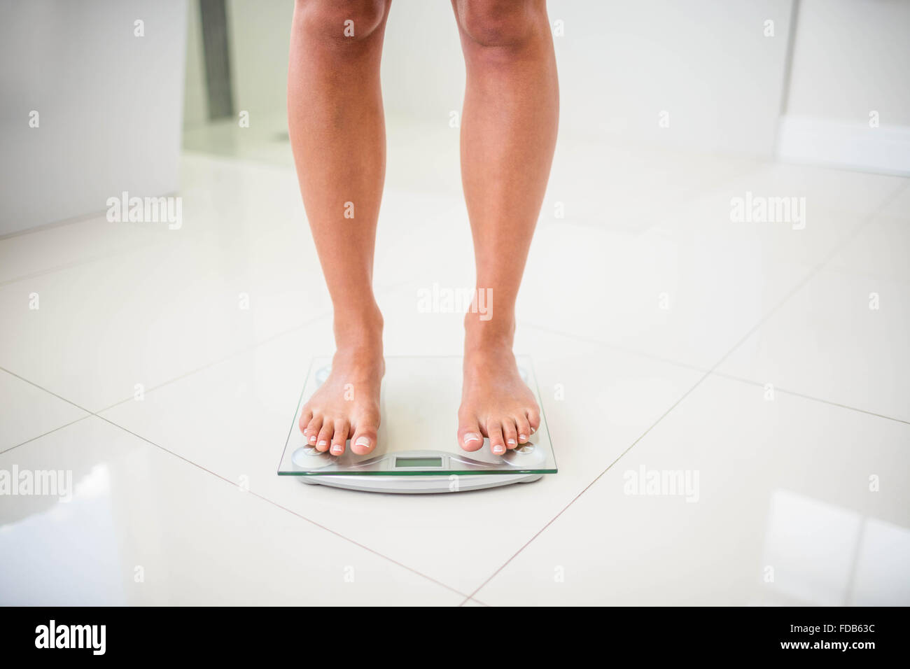 Low section of woman on weighting scale Stock Photo - Alamy