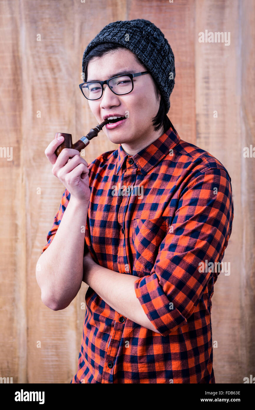 Hipster smoking pipe with crossed arms Stock Photo - Alamy