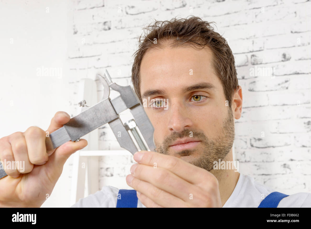 a young man measuring screw using caliper Stock Photo - Alamy