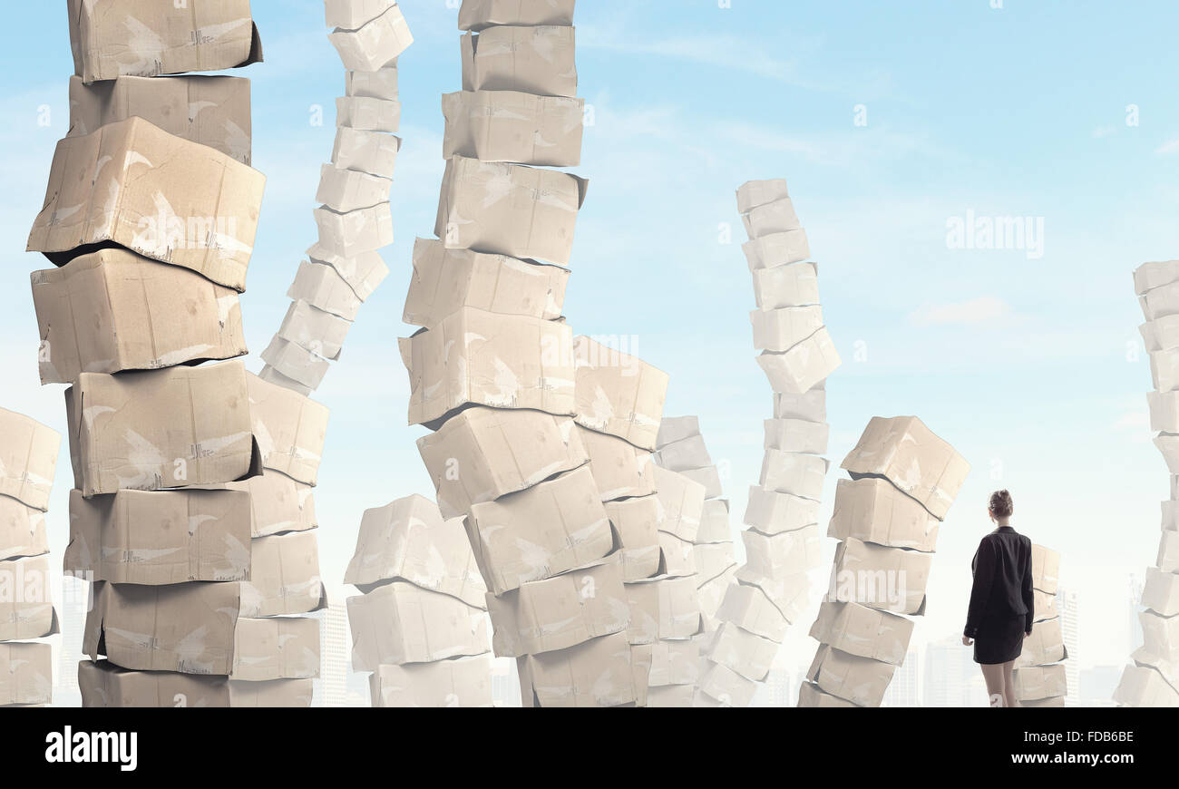 Rear view of businesswoman looking at big stack of carton boxes Stock ...