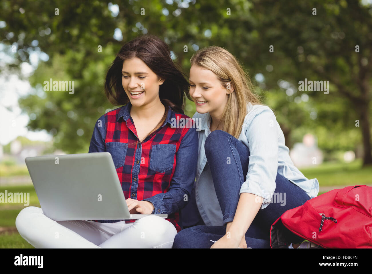 Smiling students using laptop Stock Photo - Alamy