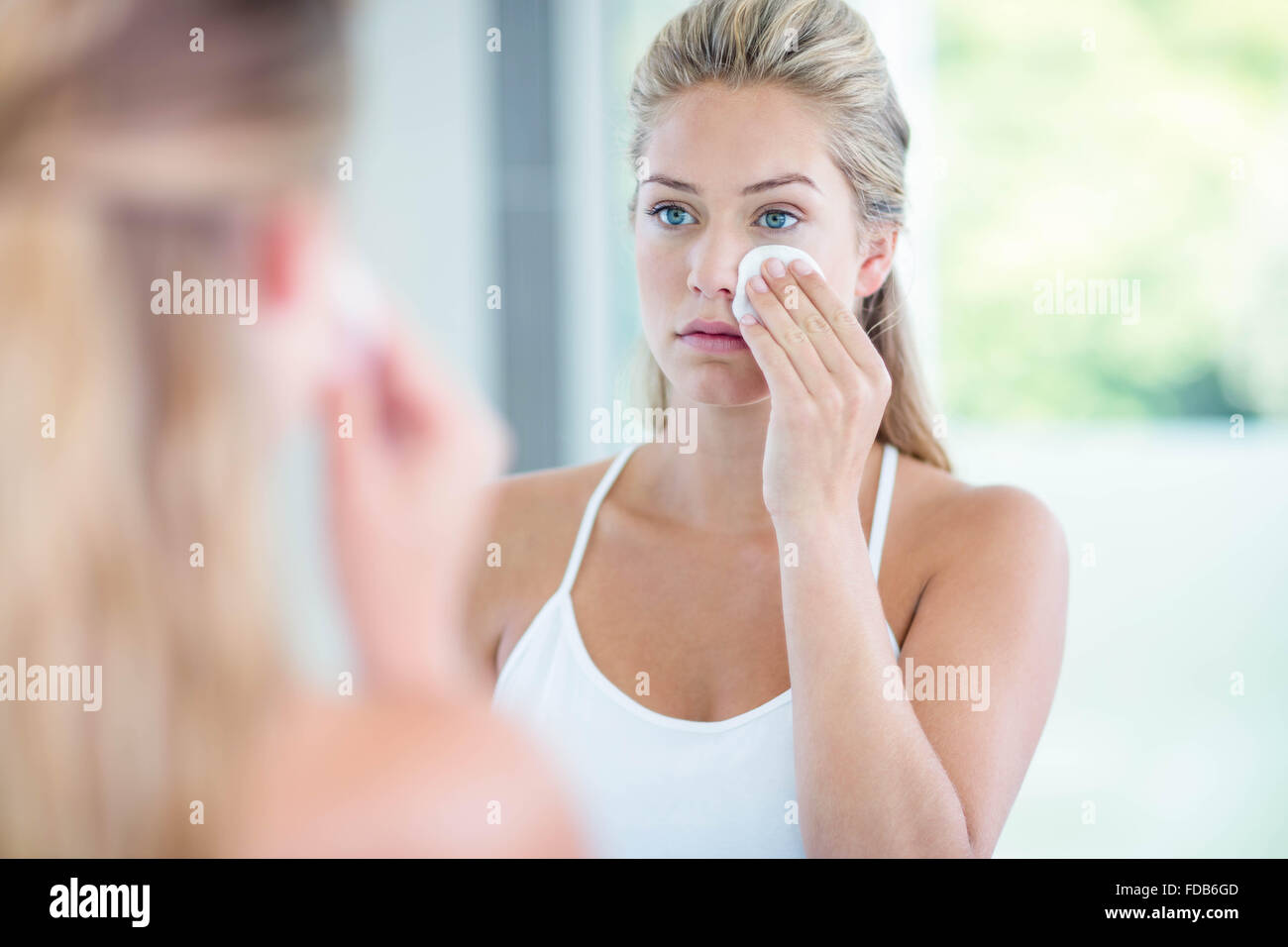 Woman wiping her face with cotton pad Stock Photo - Alamy