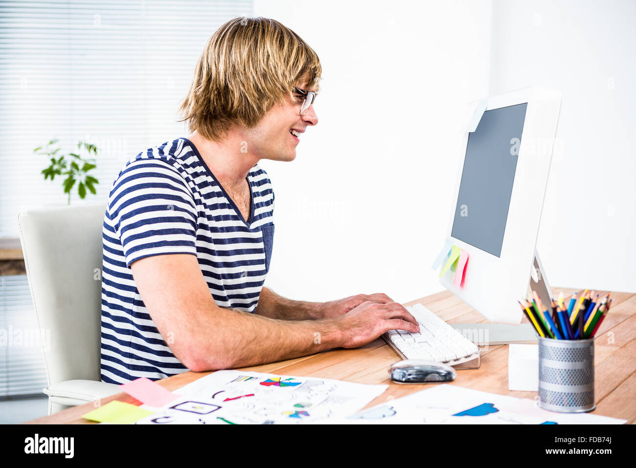 Smiling hipster businessman using his computer Stock Photo - Alamy