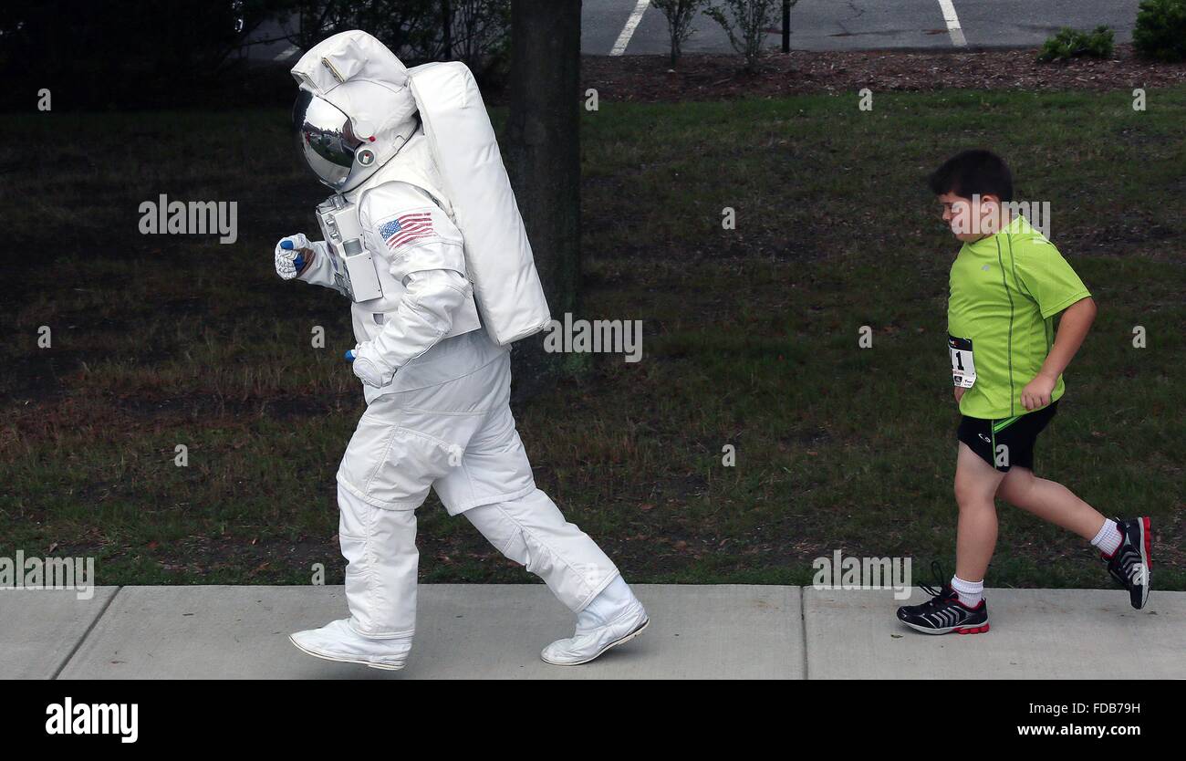 A young boy runs behind an astronaut in spacesuit during the 5k Moon ...