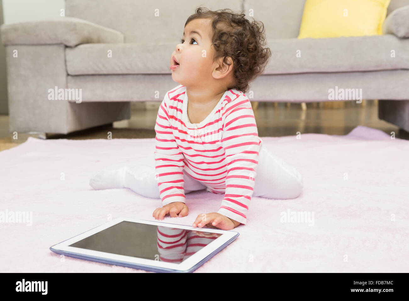 Cute baby on the carpet with tablet Stock Photo - Alamy