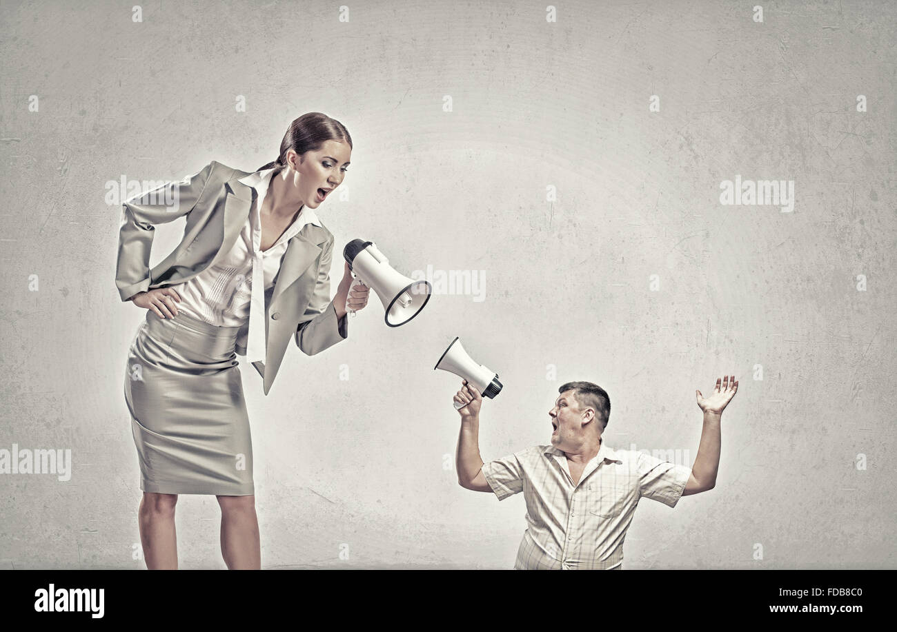 Aggressive businesswoman screaming in megaphone on her colleague Stock ...