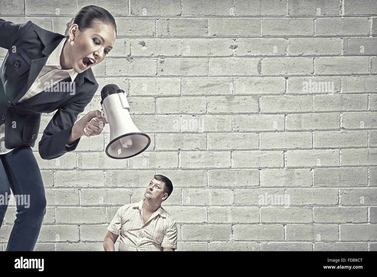 Aggressive businesswoman screaming in megaphone on her colleague Stock ...