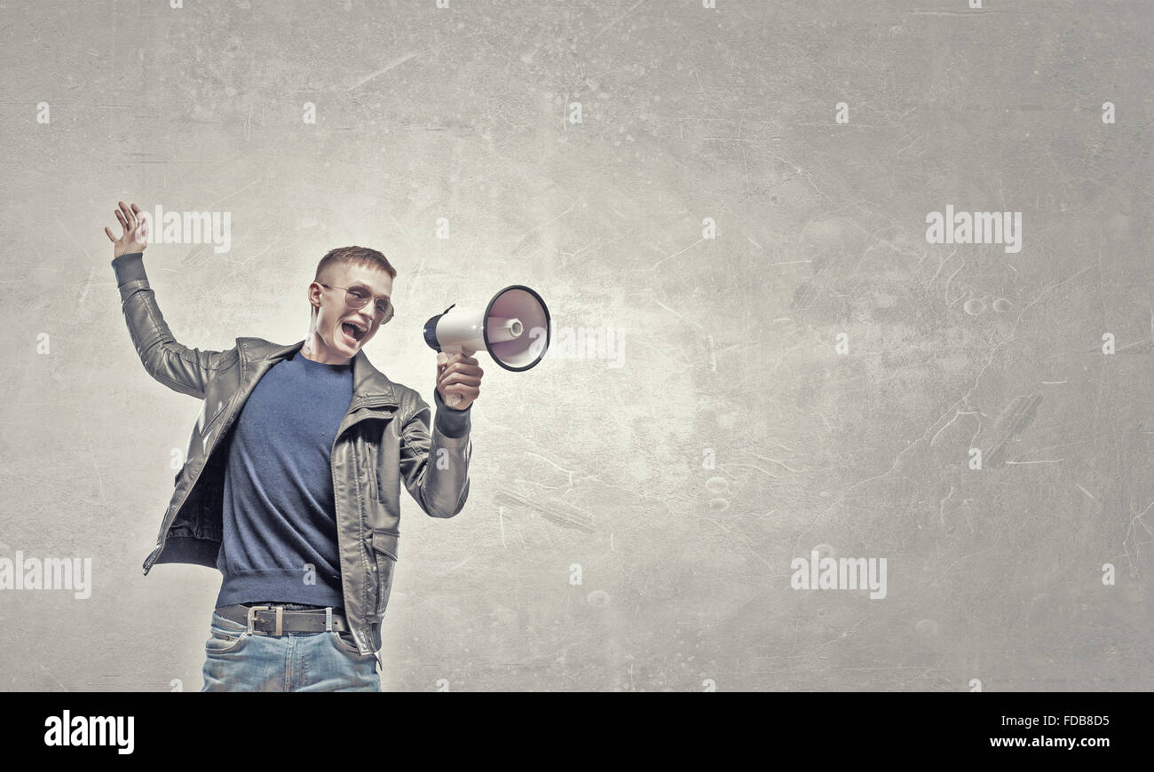 Young man in casual screaming emotionally in megaphone Stock Photo - Alamy