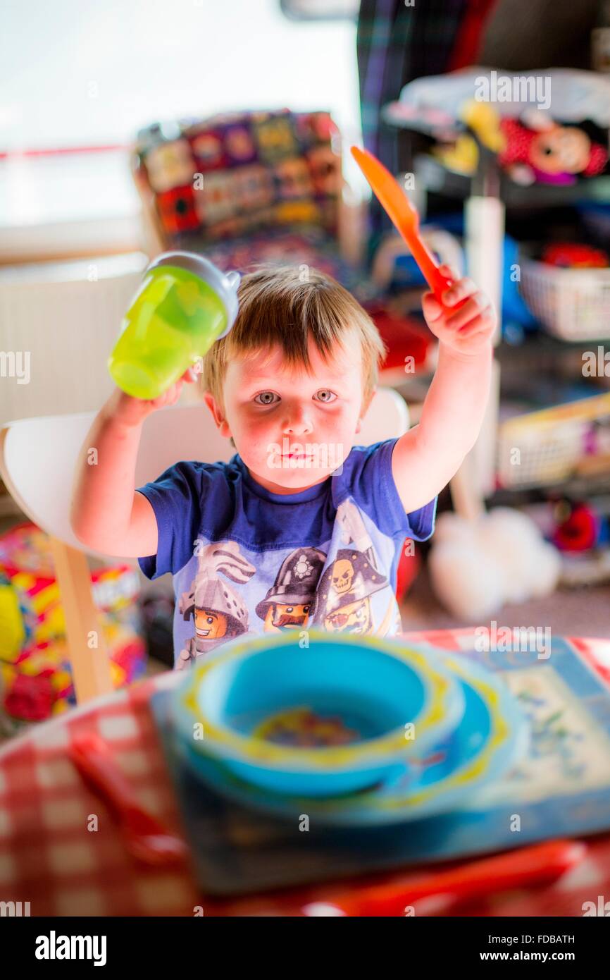 MODEL RELEASED. Young boy holding plastic beaker and knife at the ...