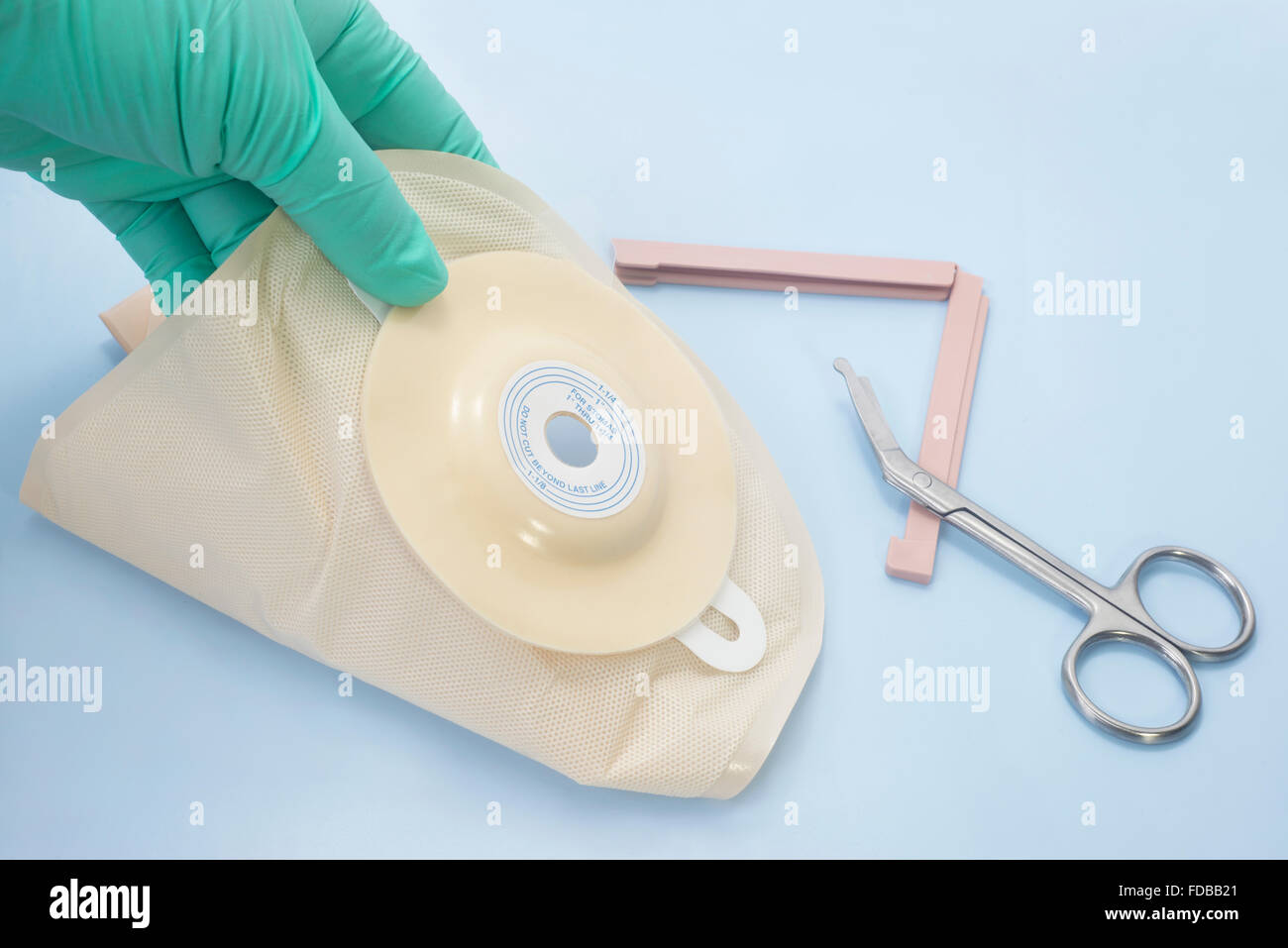 Nurse prepares ostomy supplies with scissors on blue background Stock ...